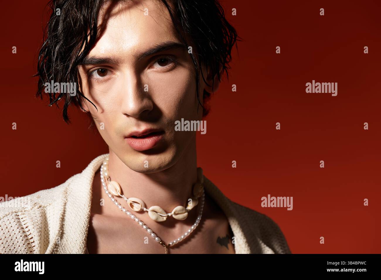 A slim young man poses confidently in a stylish summer outfit with ...