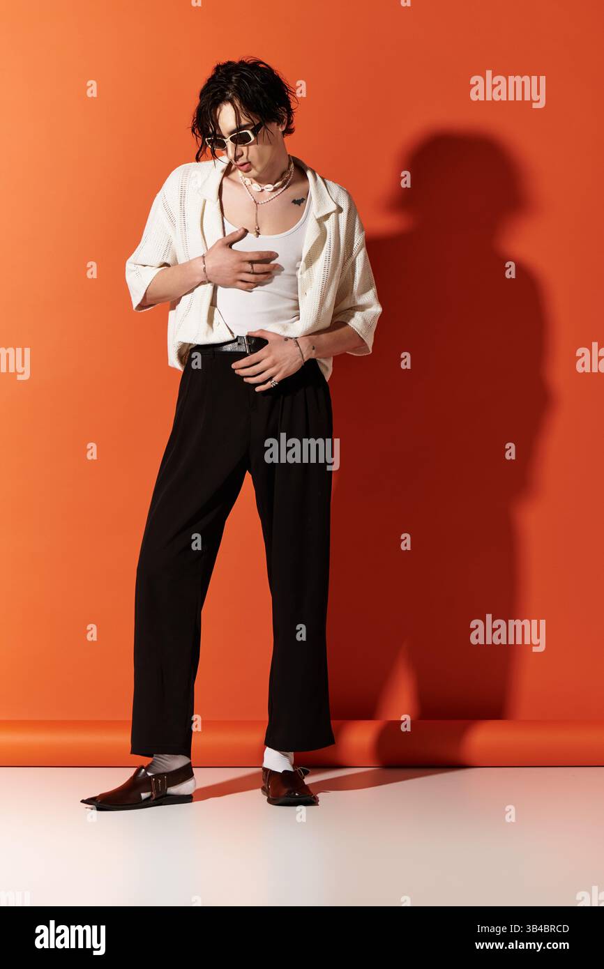 Young man poses confidently in a fashion-forward summer outfit against ...