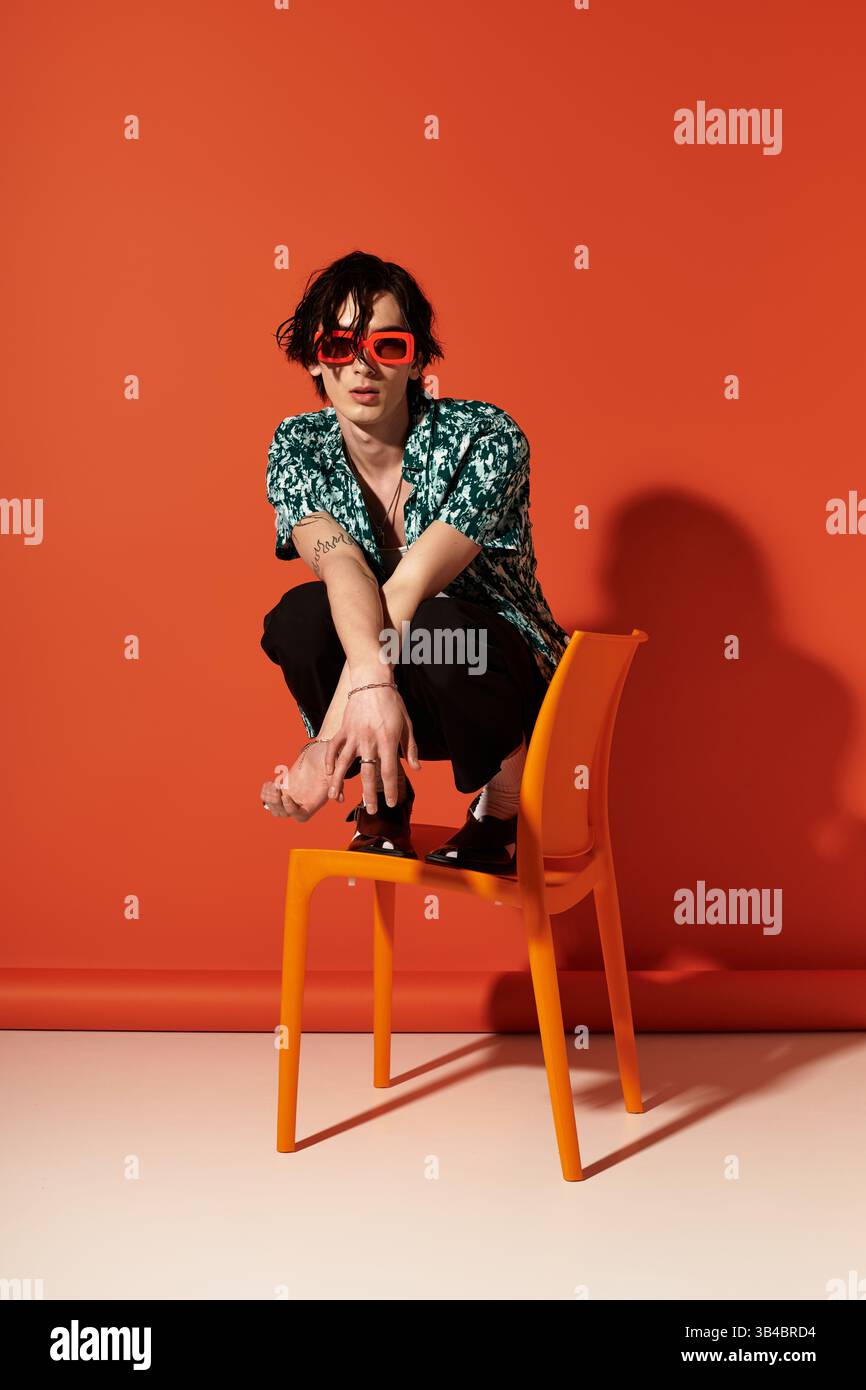 A slim young man poses confidently in a stylish summer outfit against a ...