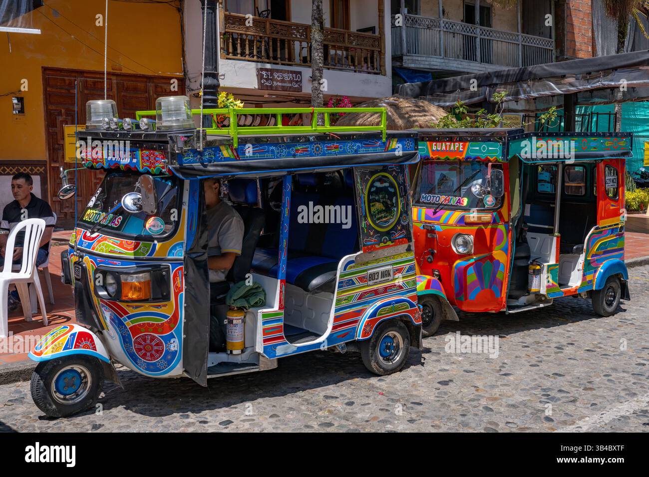 A line of a colorful motochivas or mototaxis, tourist transportation in ...