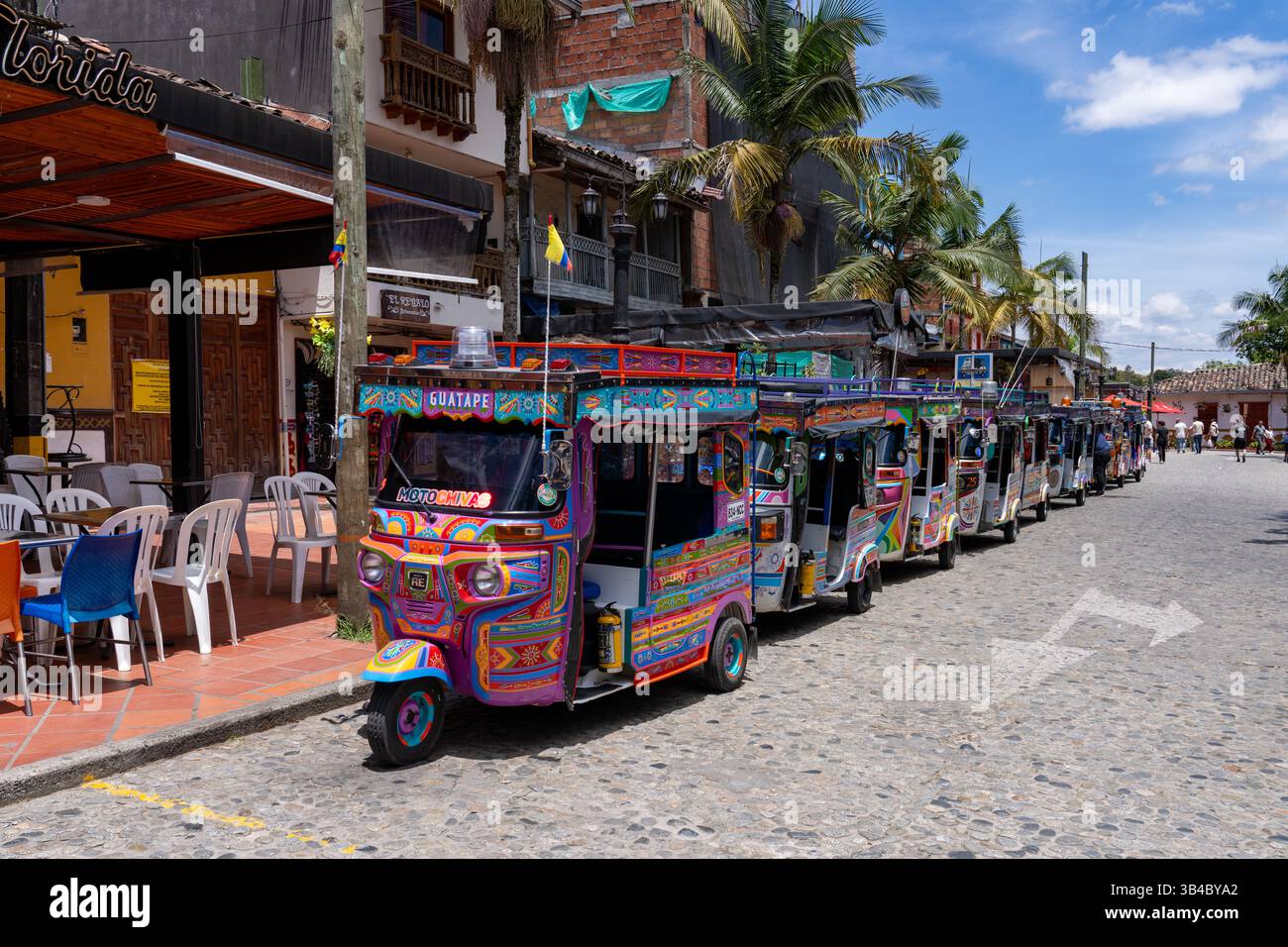 A line of a colorful motochivas or mototaxis, tourist transportation in ...