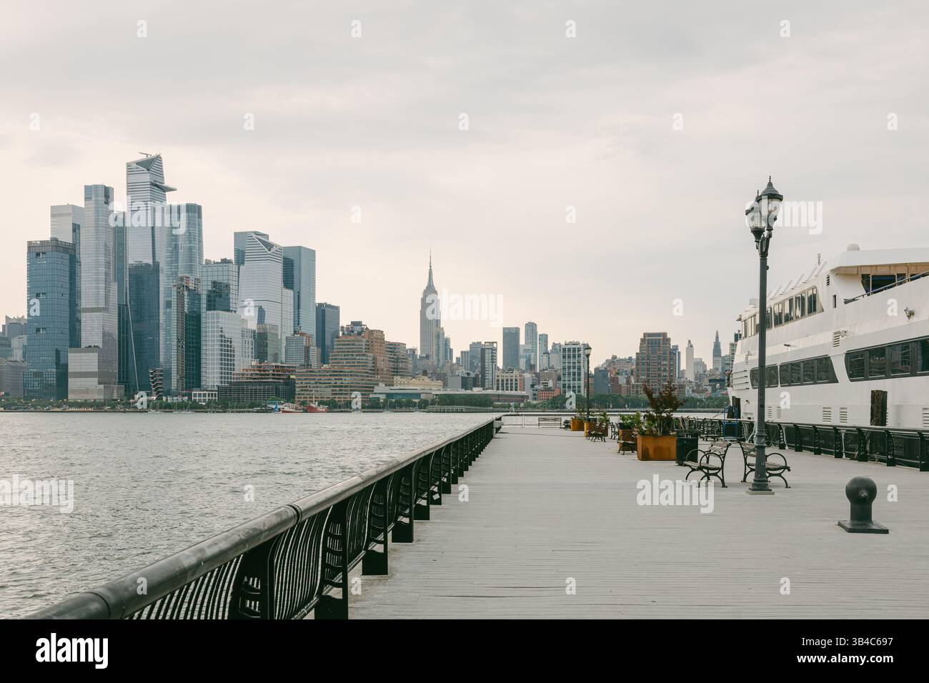 Waterfront promenade showcases New York City skyline with ships docked ...