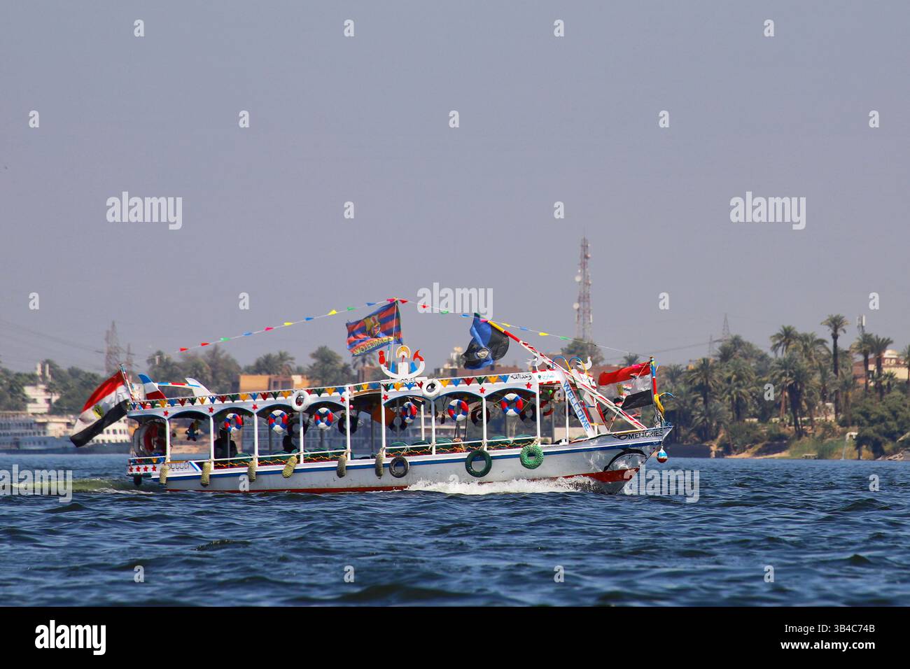 Traditional decorated motorboat cruising the Nile River in Egypt with ...