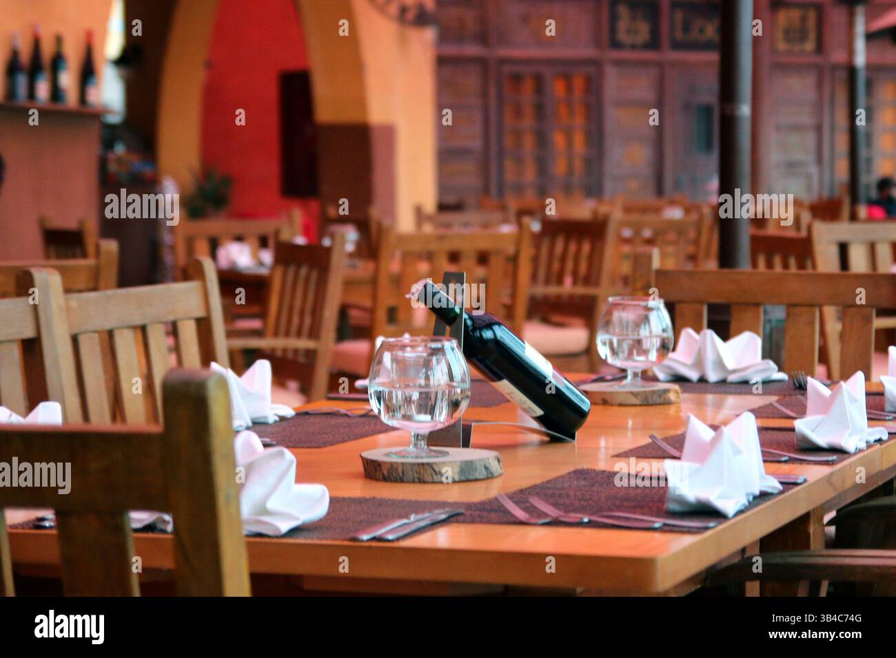 Stylish restaurant interior featuring a set table with wine bottle ...