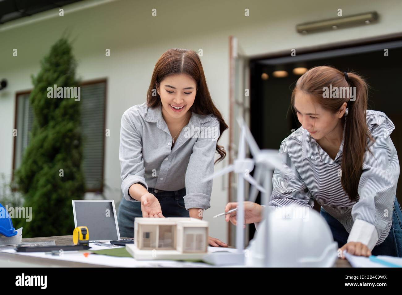 Sustainable Practices in Architecture. Architects reviewing plans for an eco-friendly building ...