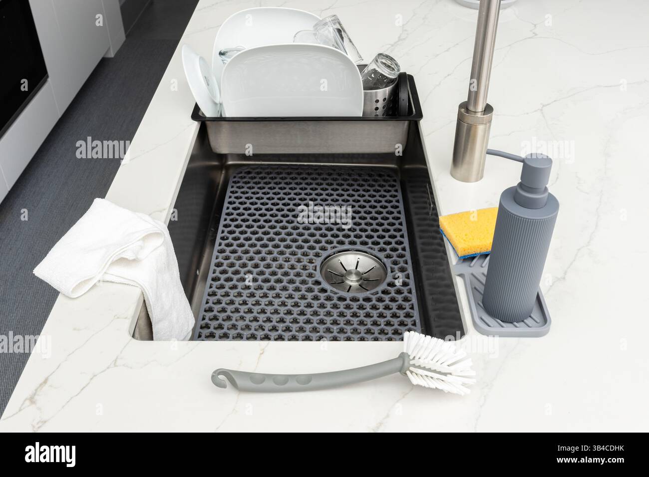 Set of dish cleaning tools next to the sink in a modern, minimalist ...