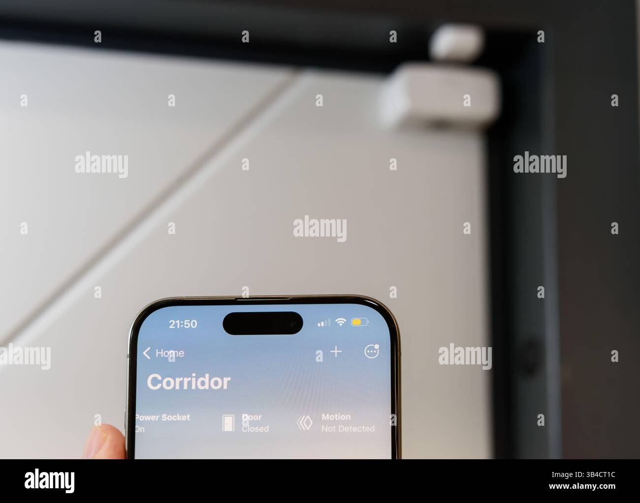 A close-up of a smartphone displaying a smart home interface, showing ...