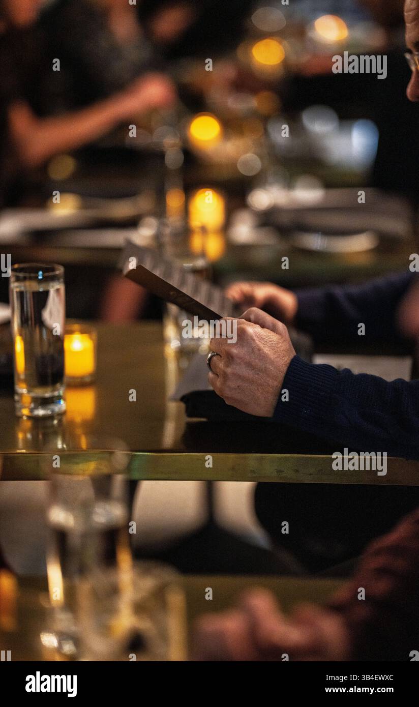 Bartender's Hand Holding Menu at Golden Hour Stock Photo - Alamy