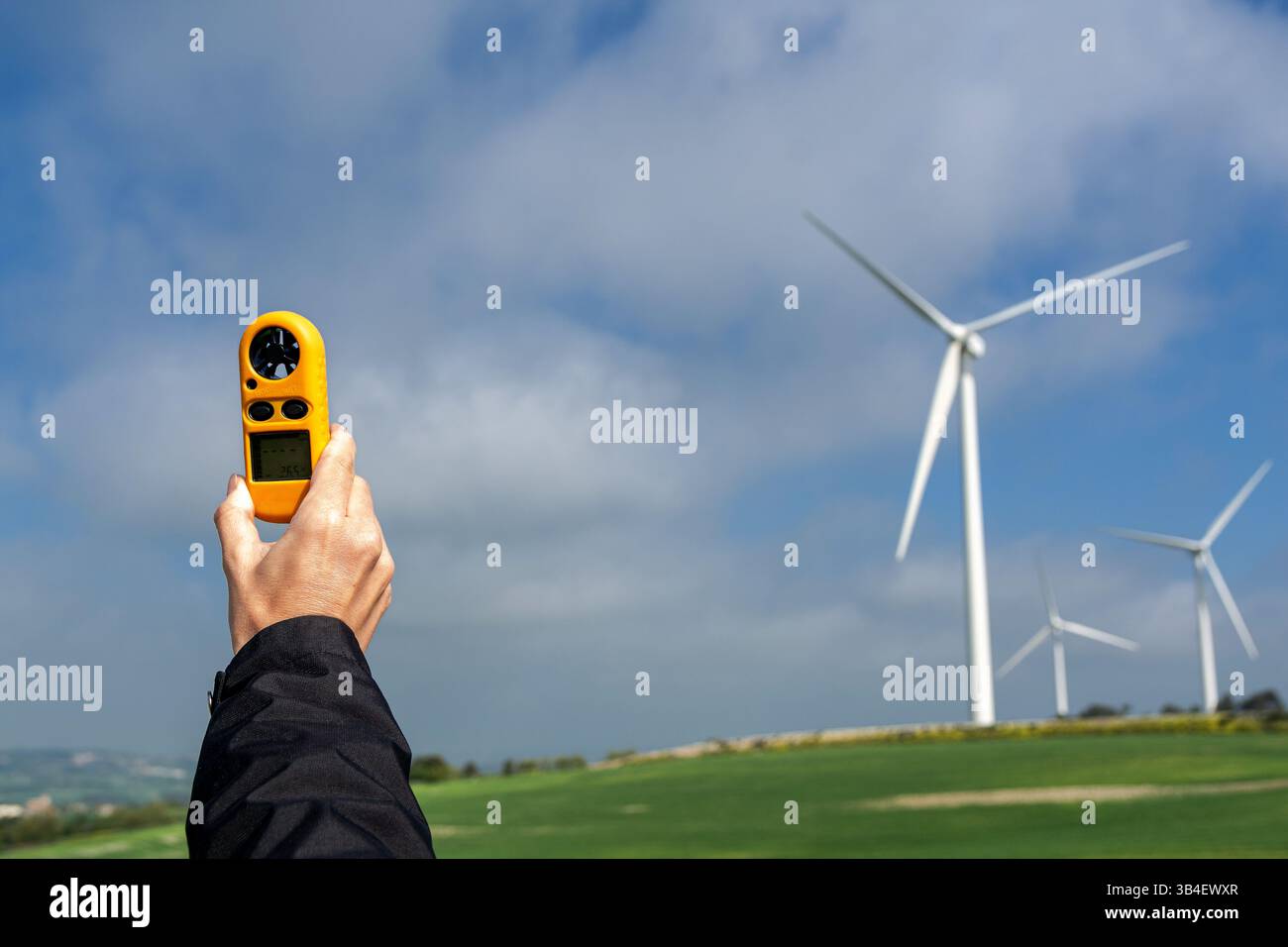 Engineer measuring wind speed for renewable energy with anemometer and ...