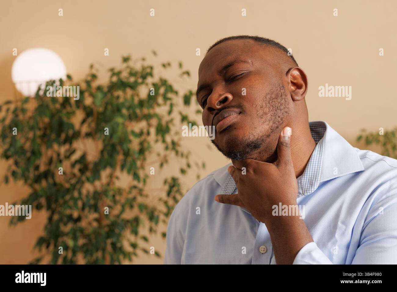 Man suffering from sore throat, holding neck in discomfort. Concept of ...