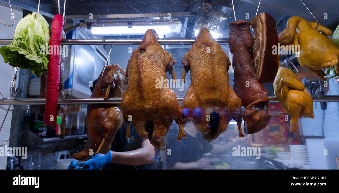 Hanging roasted meats in a traditional eatery, whole ducks, sausages ...