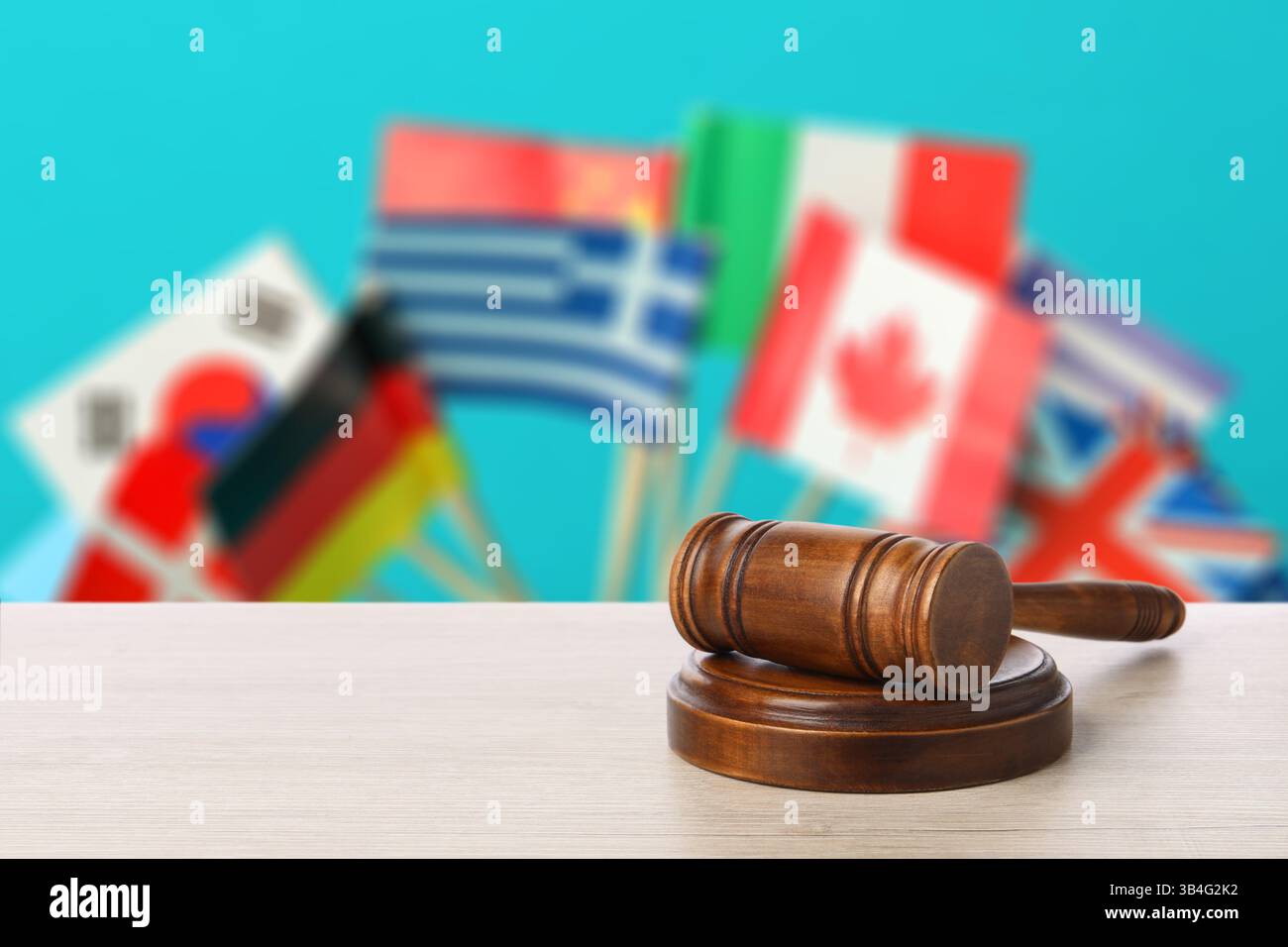 Judge's gavel on wooden table against flags of different countries ...