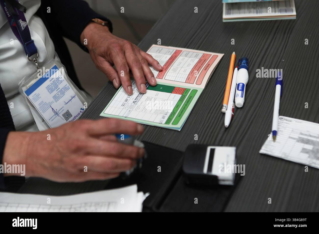A health worker stamps a vaccination card at the health center where ...