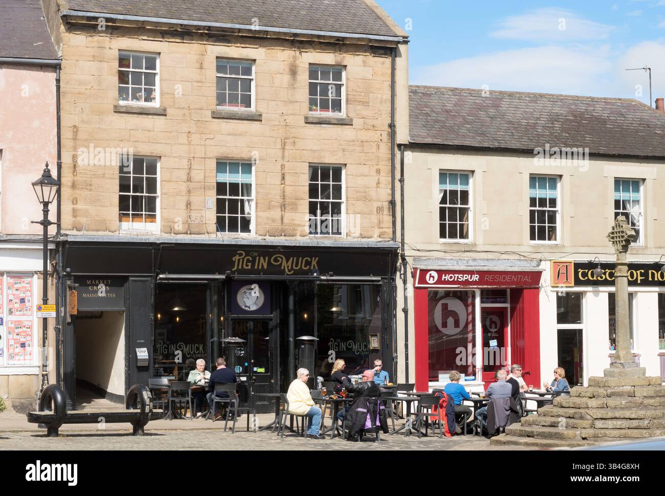 People sitting drinking outside the Pig in Muck in Alnwick Market Place ...