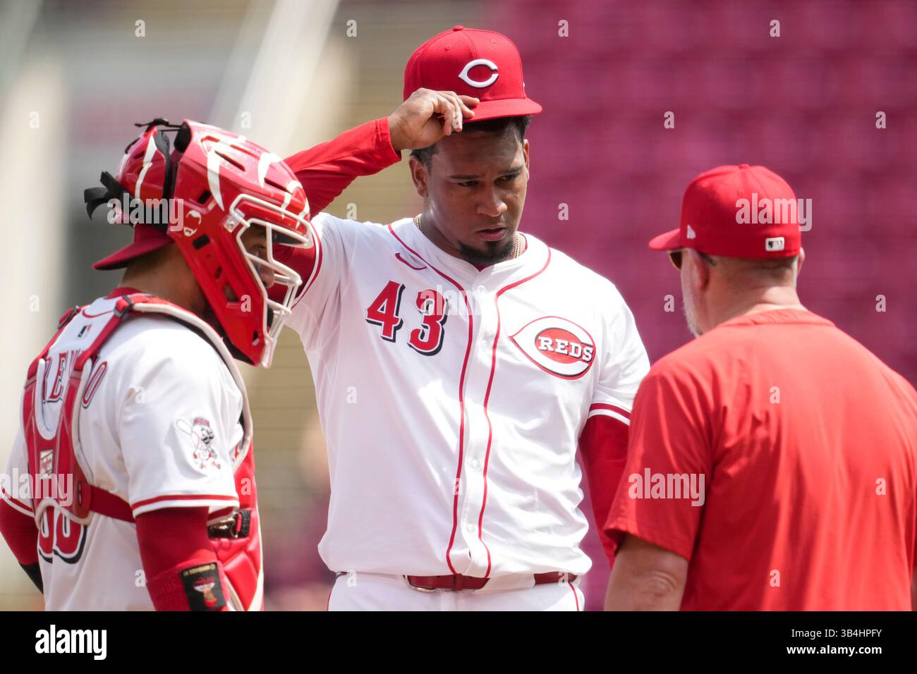 Cincinnati Reds pitcher Alexis Díaz (43) speaks with pitching coach ...