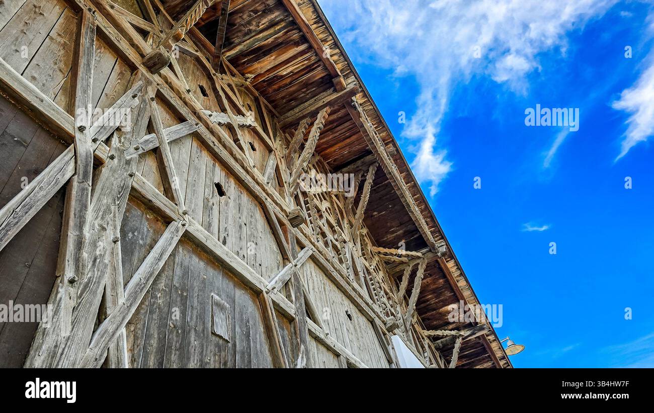 A part of a traditional Austrian wooden house against a blue sky with ...