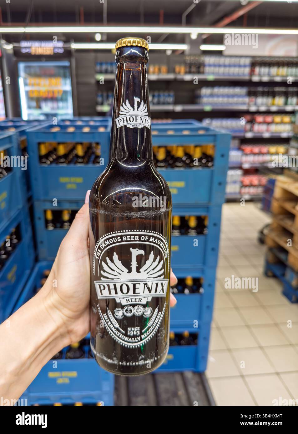 Grand Bay, Mauritius - January 29, 2025: Hand holding a bottle of ...