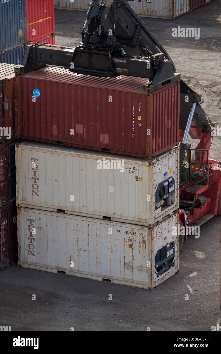 Crane loading shipping containers at a busy port during daylight hours ...