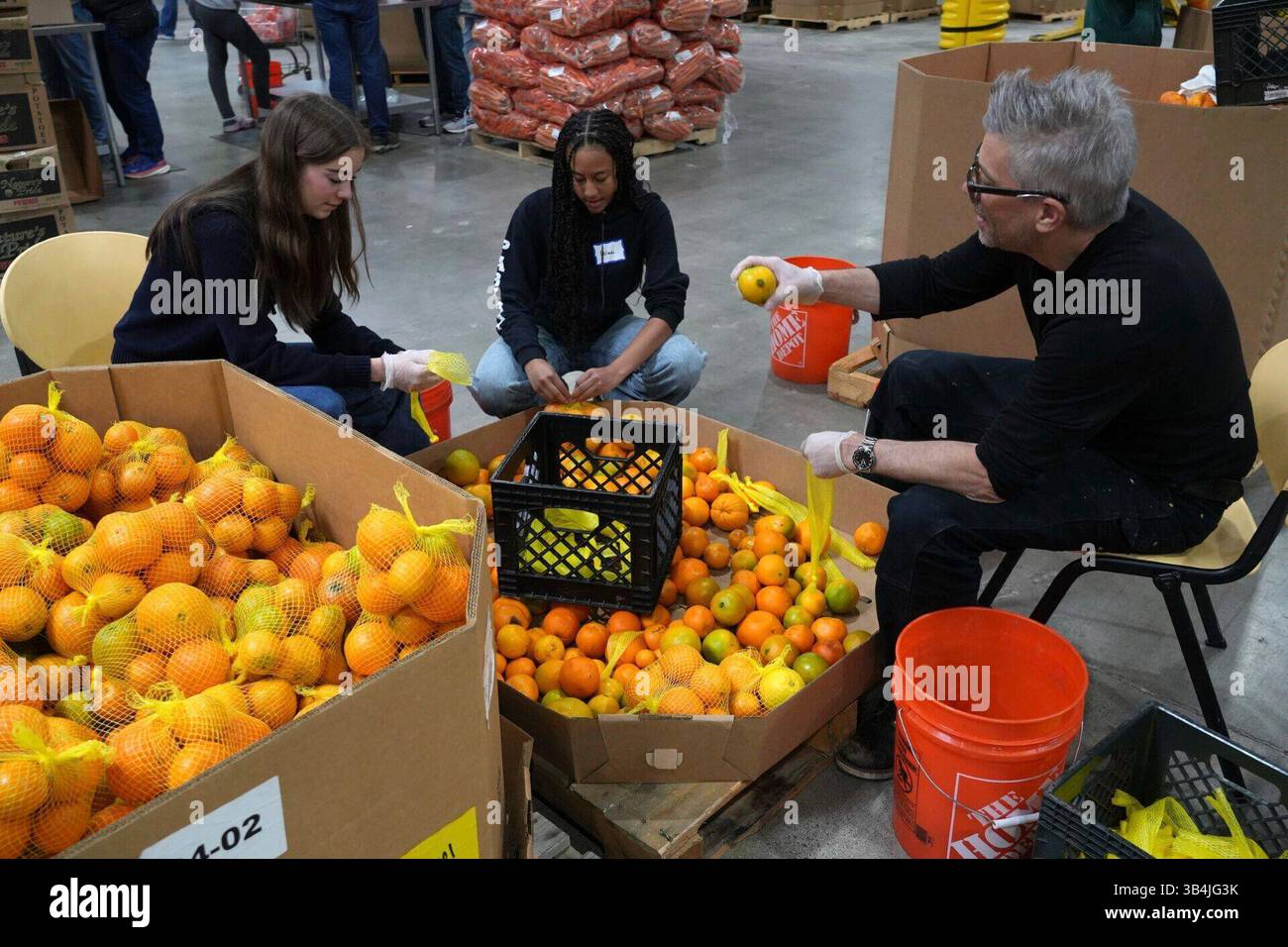 Volunteers pack produce at the Alameda County Community Food Bank in ...