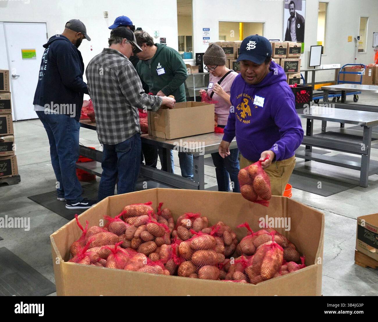 Volunteers pack produce at the Alameda County Community Food Bank in ...