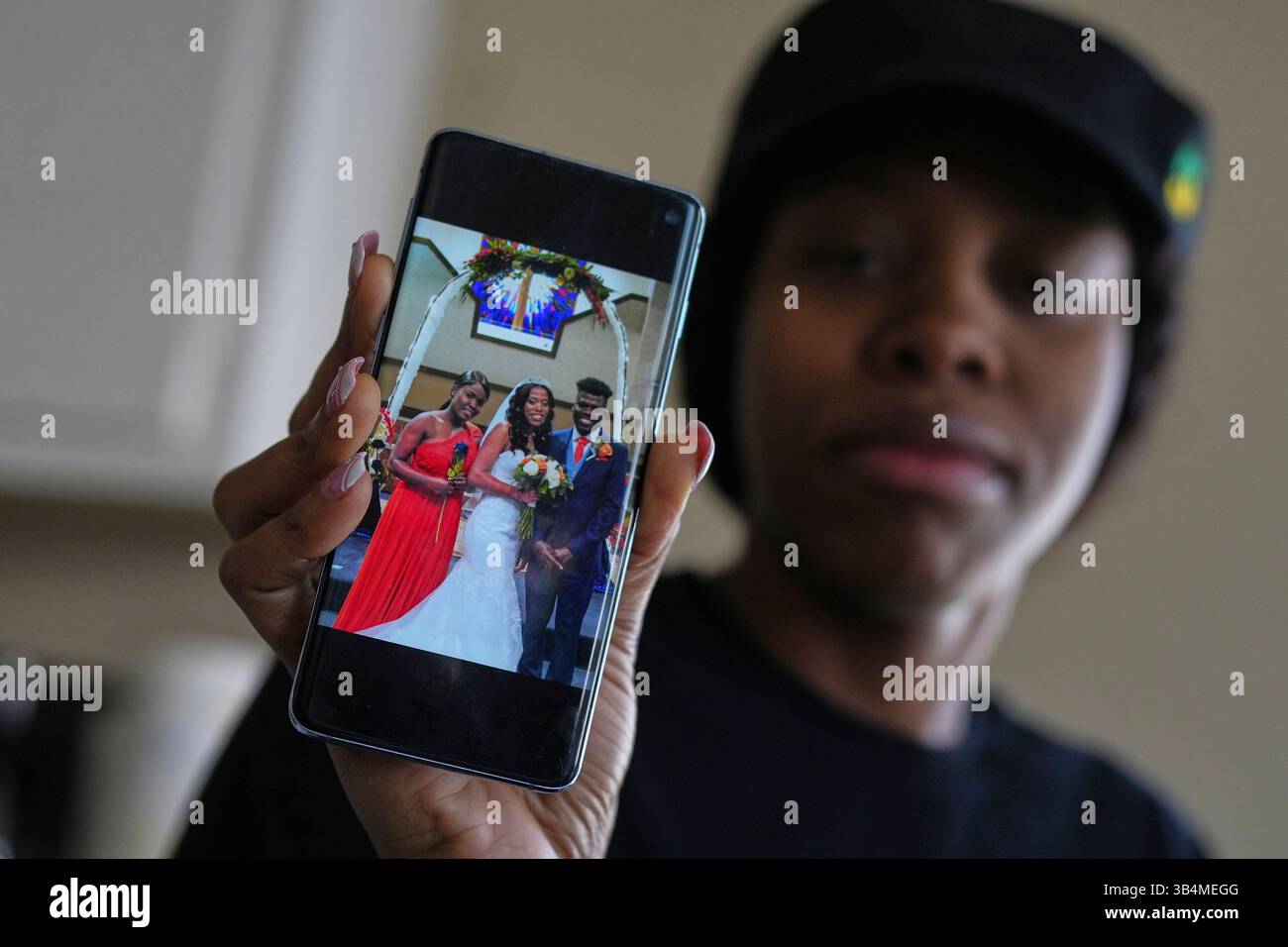 Haitian immigrant Sherlie Jean, a fast food worker, shows photos from ...