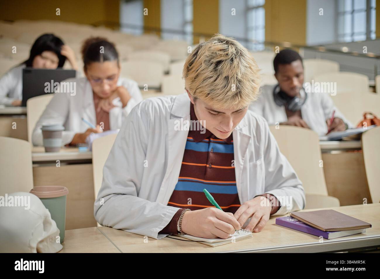 Medical Student Writing Notes in Lecture Hall Stock Photo - Alamy