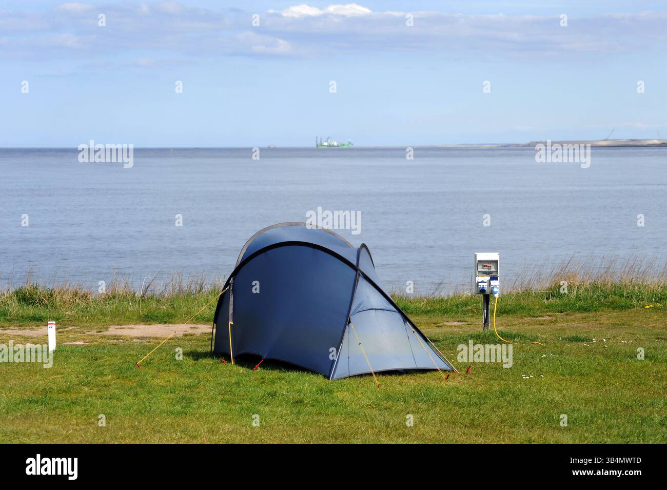 ONE MAN TENT ON CAMPSITE LOOKING OUT TO SEA IN BRITISH COASTAL AREA RE ...