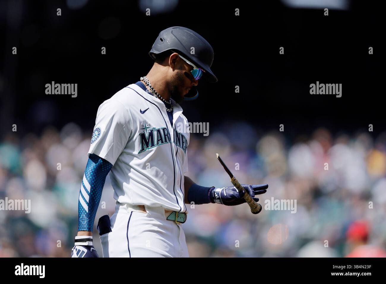 Seattle Mariners' Julio Rodríguez looks at his broken bat after ...