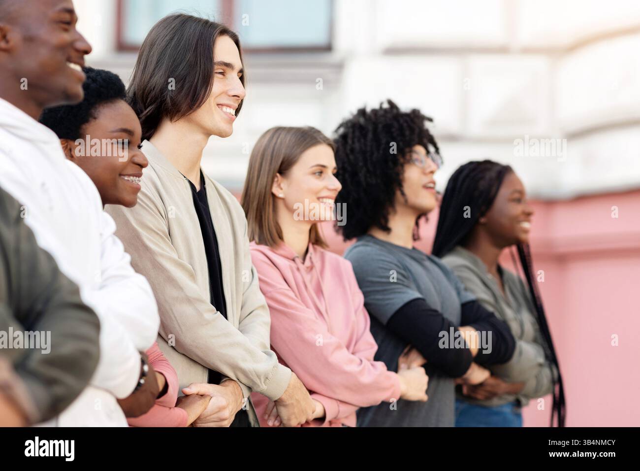 Multiracial millennial people holding crossed hands, making strike ...