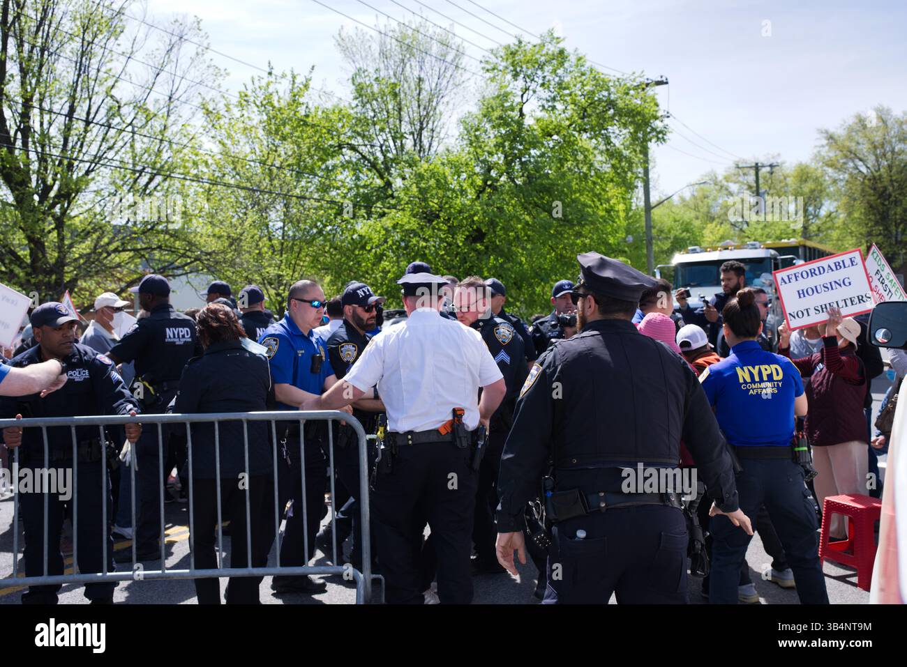 A group of NYPD officers in uniform interacts with protestors holding ...