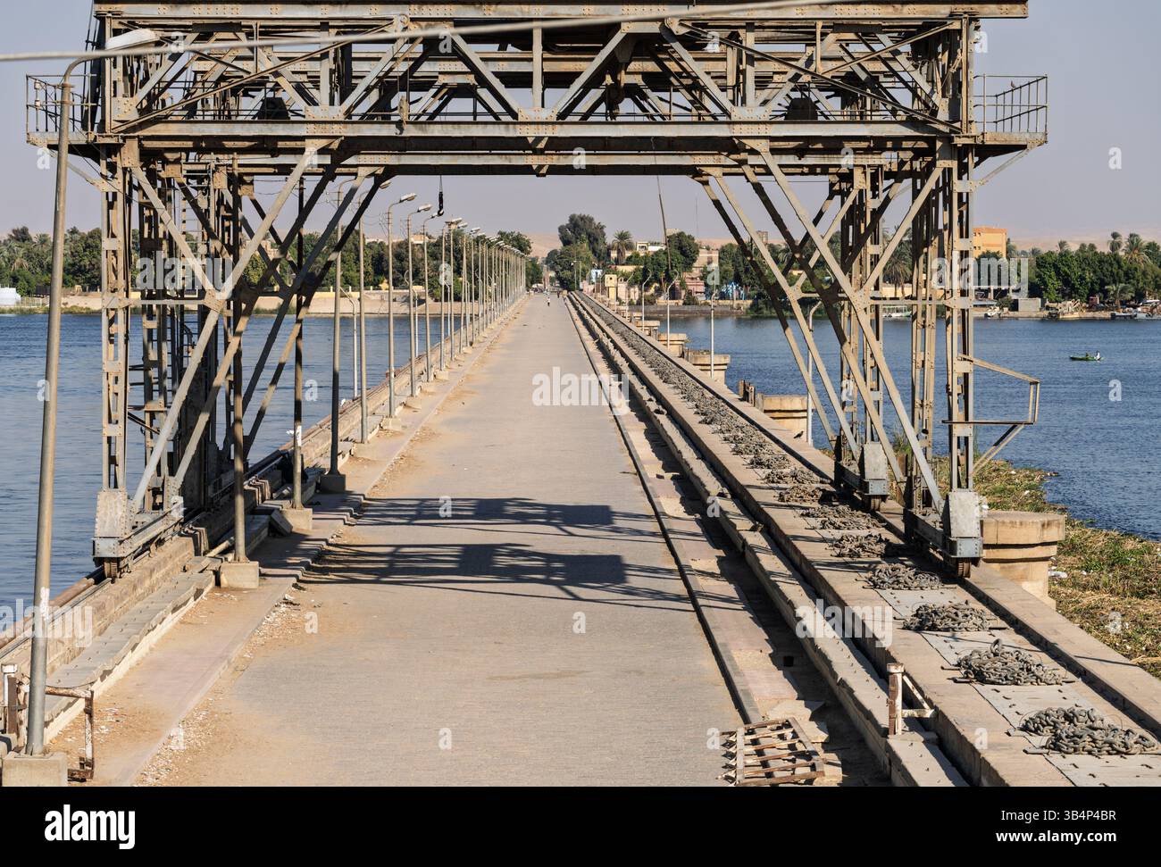 Road across old Esna dam and lock across the Nile River with sandy ...