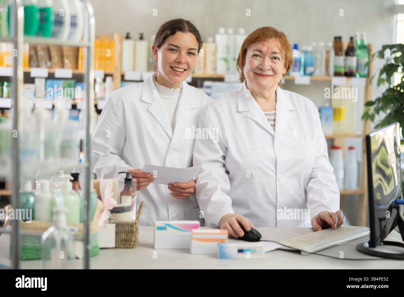 Two female pharmacists checking prescription on computer Stock Photo ...