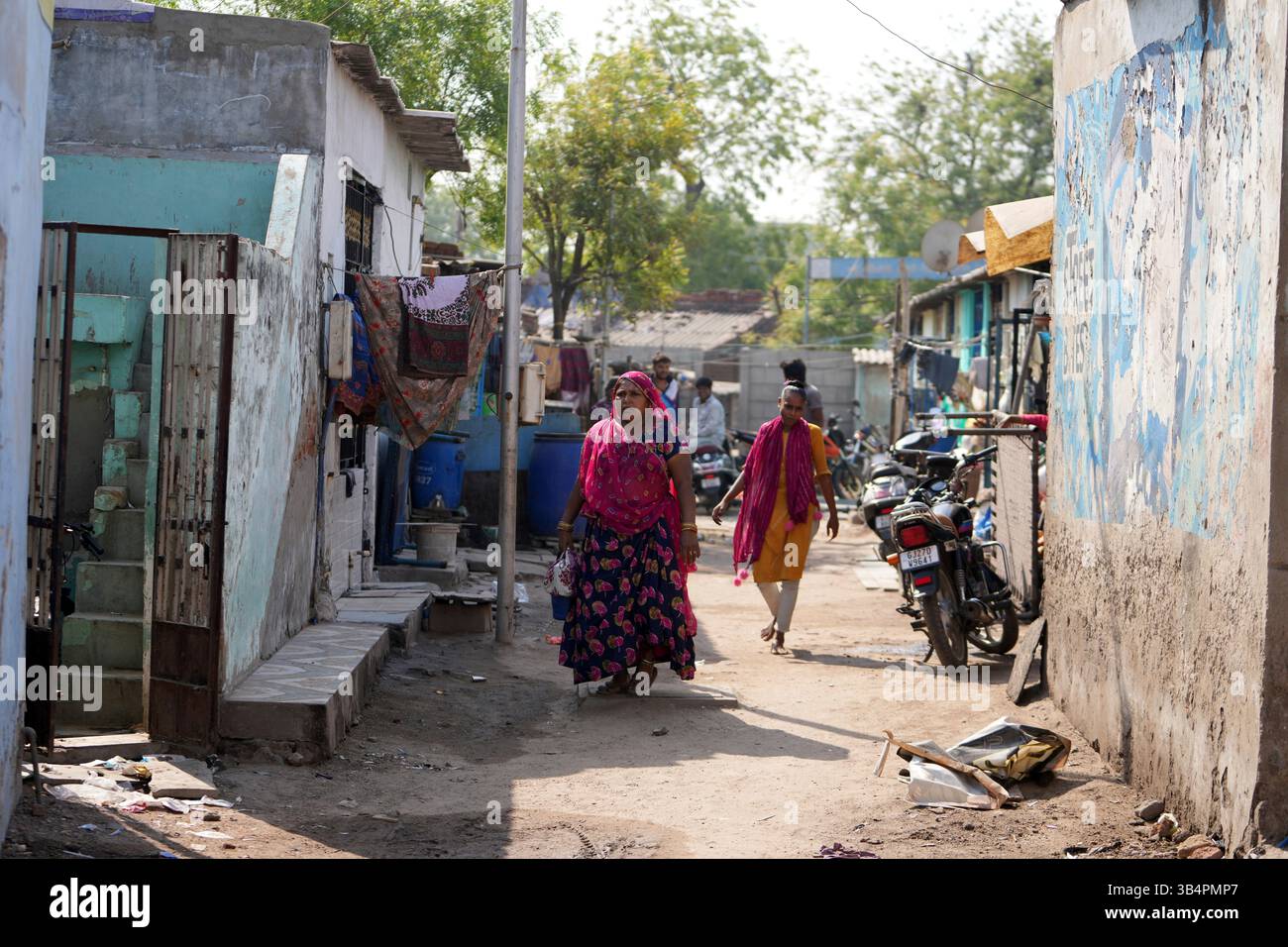 People walk through buildings in Vanzara Vas, a low-income neighborhood ...