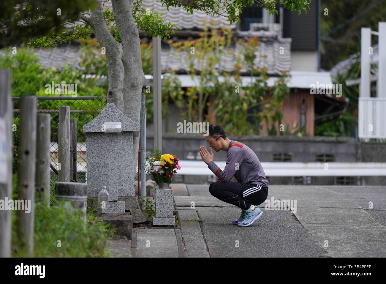 A man prays in front of a Jizo statue enshrined near the Hyakken ...