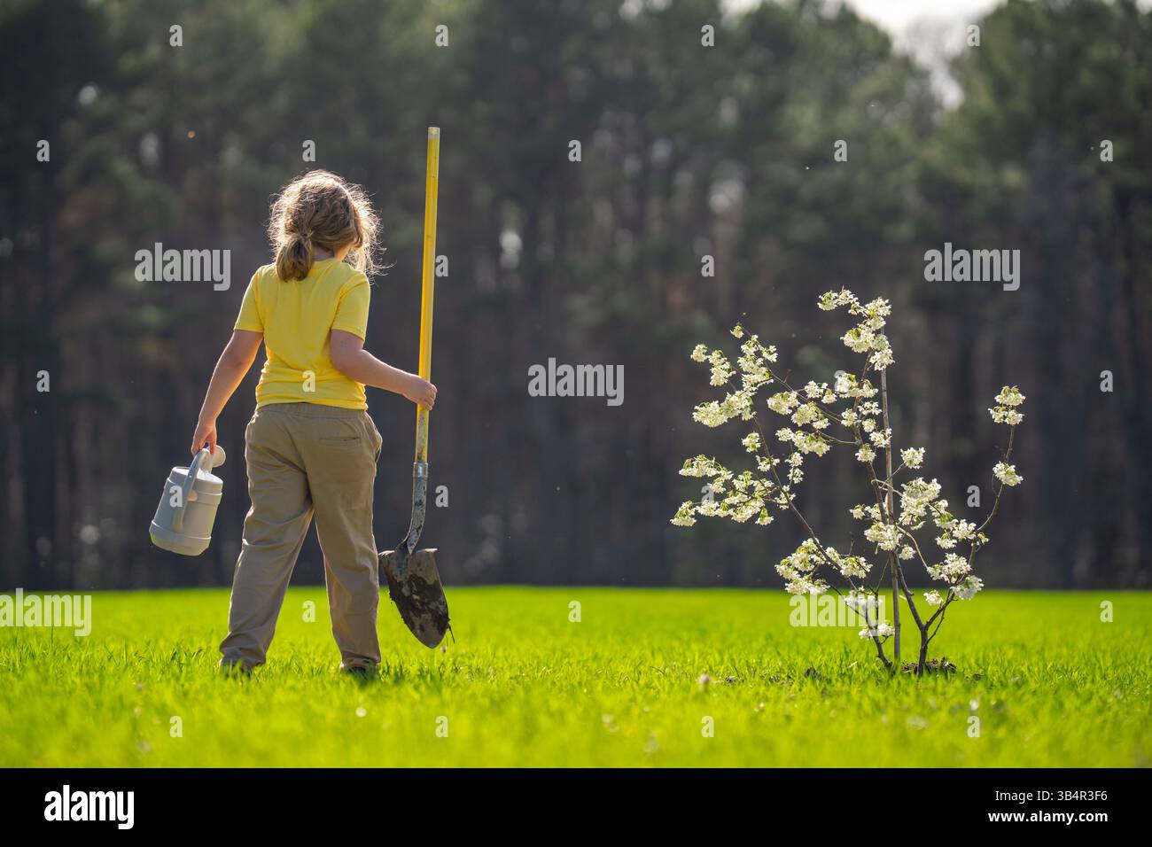 Kid growing a tree in garden. Kid digging soil with shovel and planting ...