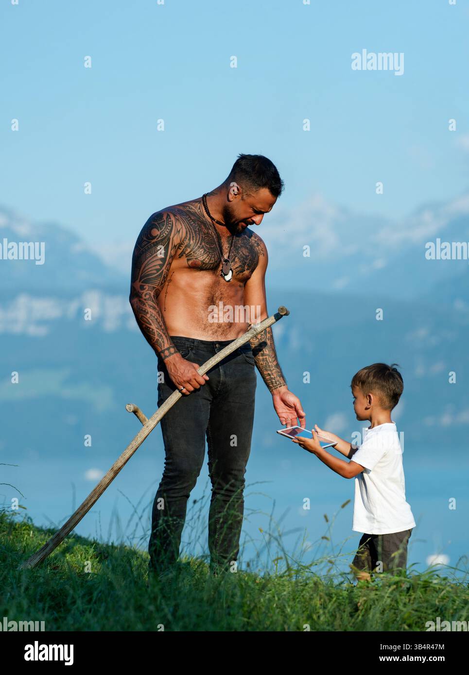 Farmers father and his son work together on summer farm field. The ...