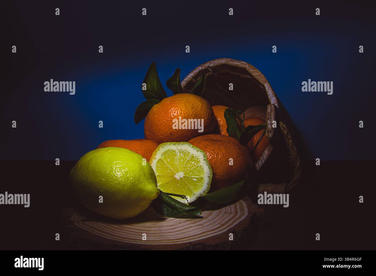 A dramatic still life composition of fresh citrus fruits including ...
