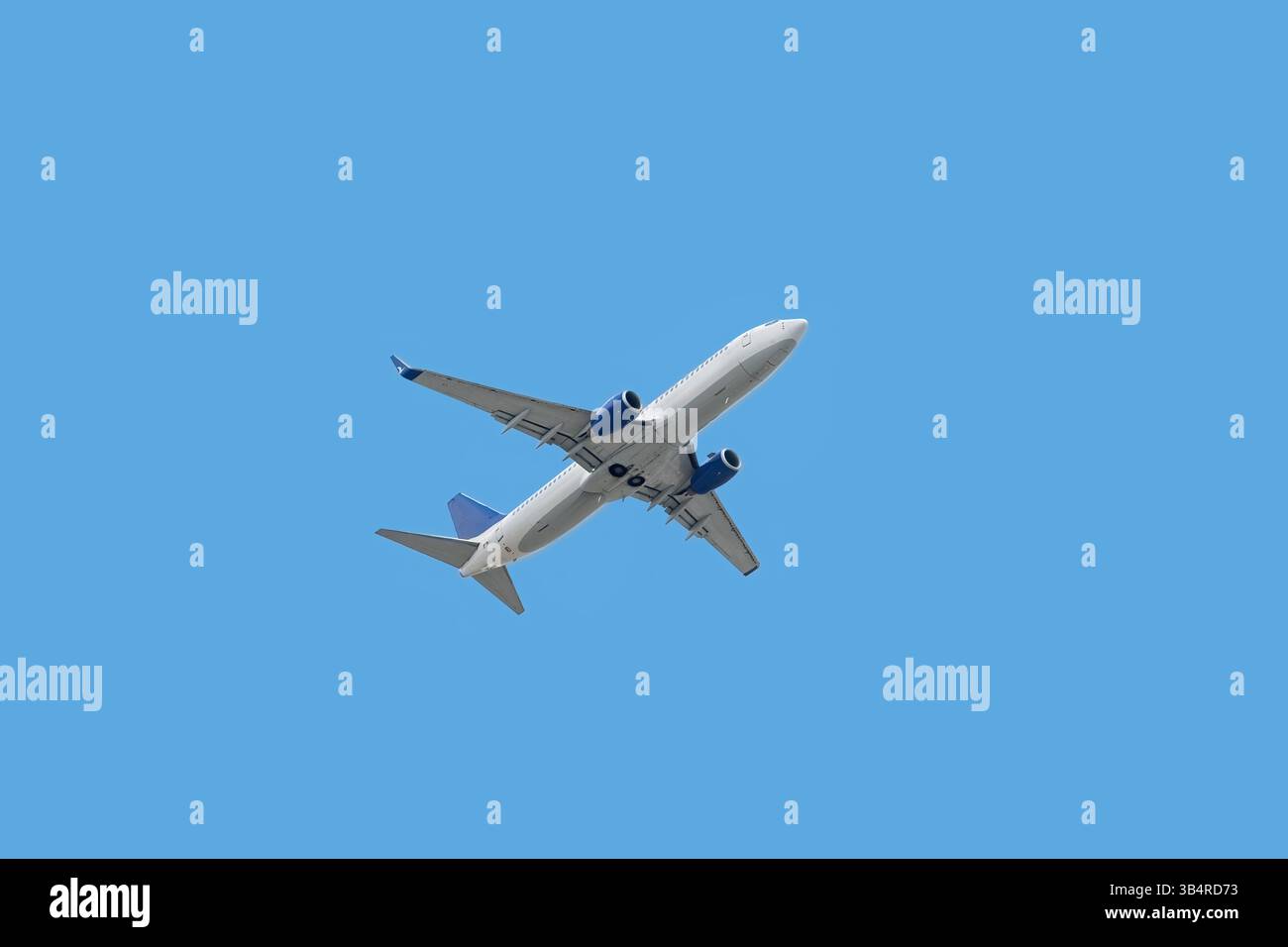 Bottom view of passenger plane taking off in blue sky Stock Photo - Alamy