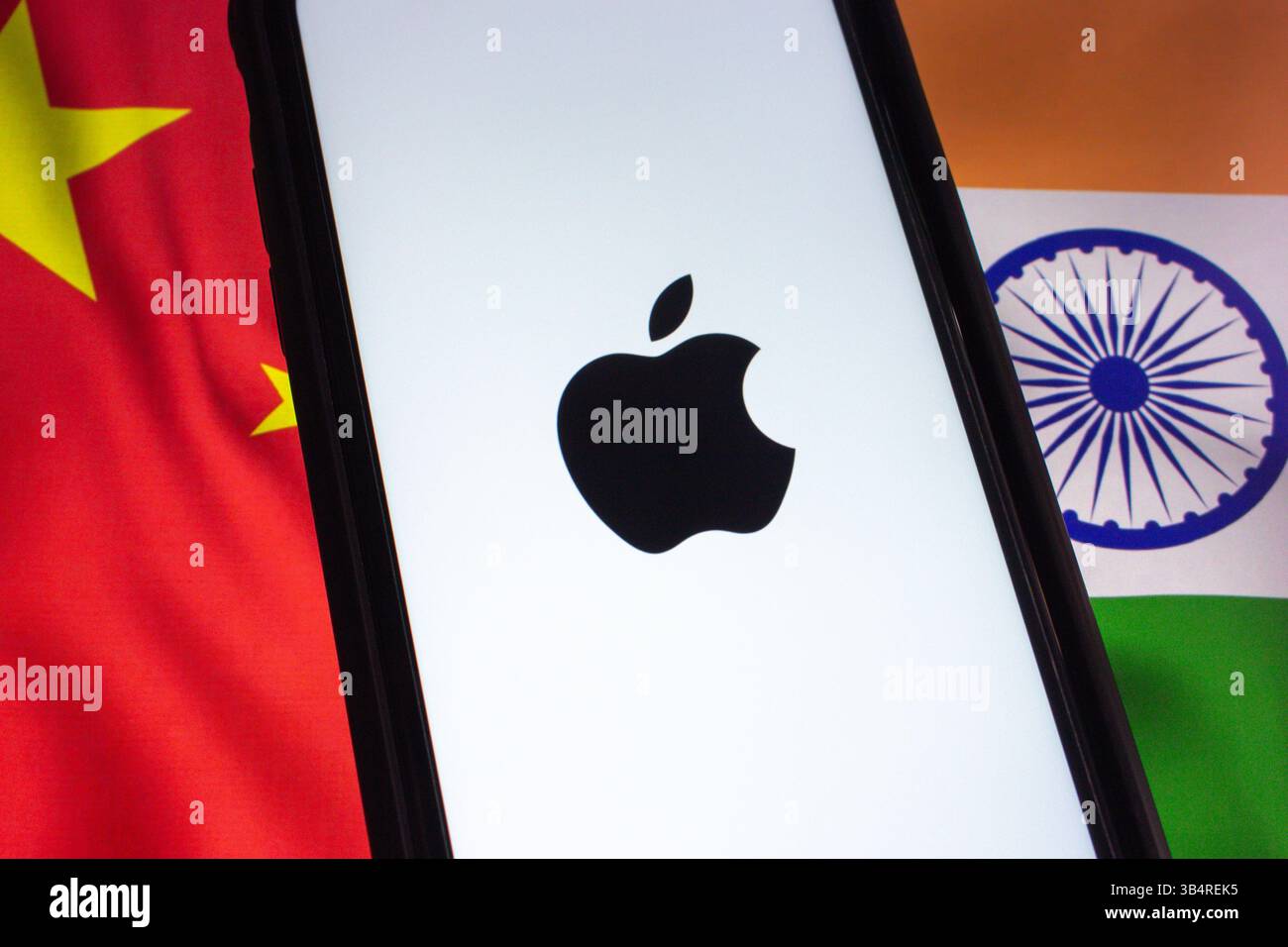 Close-up of a smartphone displaying the Apple logo, placed against the ...