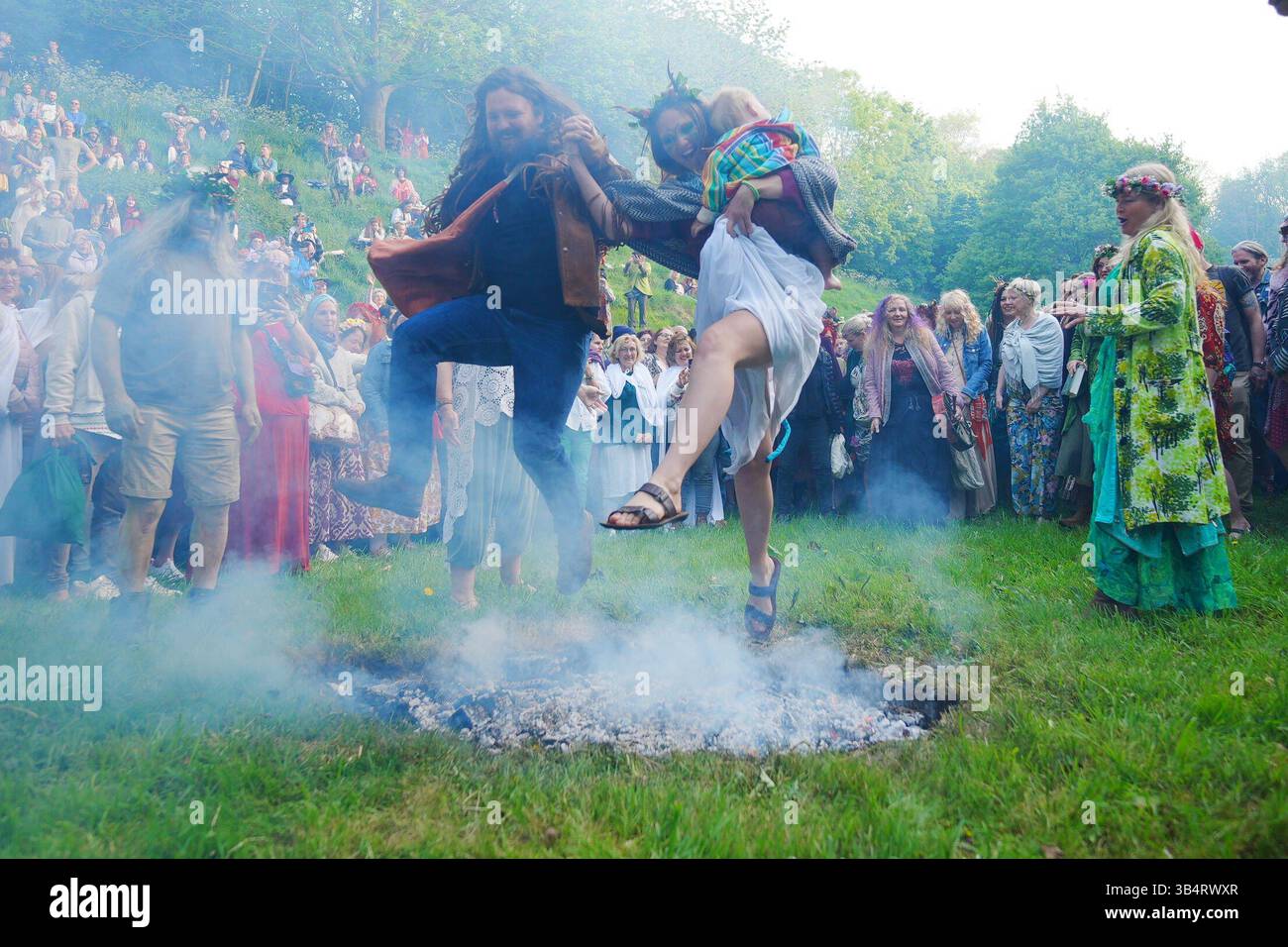 People jump the fire during the Beltane celebrations at Glastonbury ...