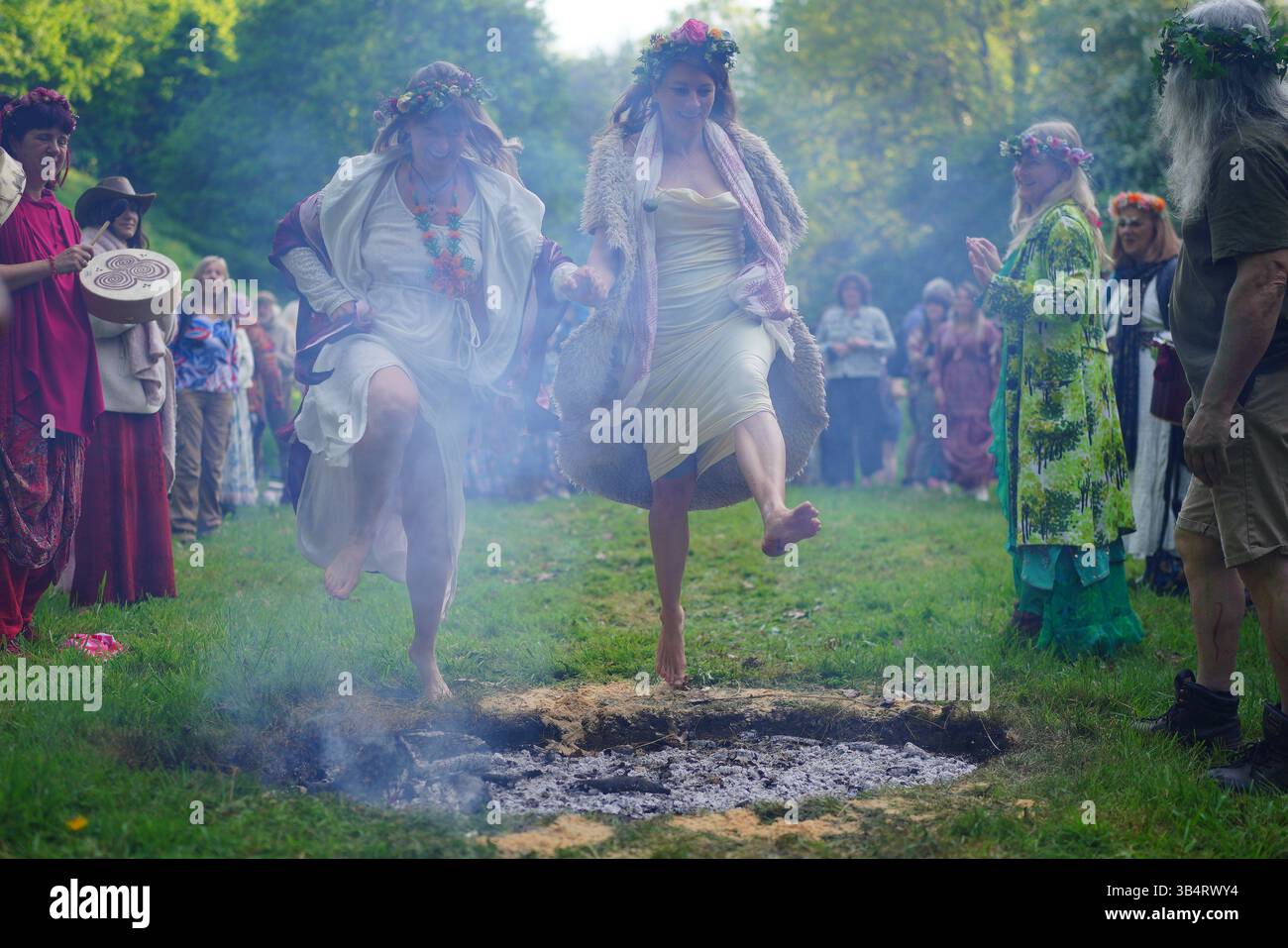 People jump the fire during the Beltane celebrations at Glastonbury ...