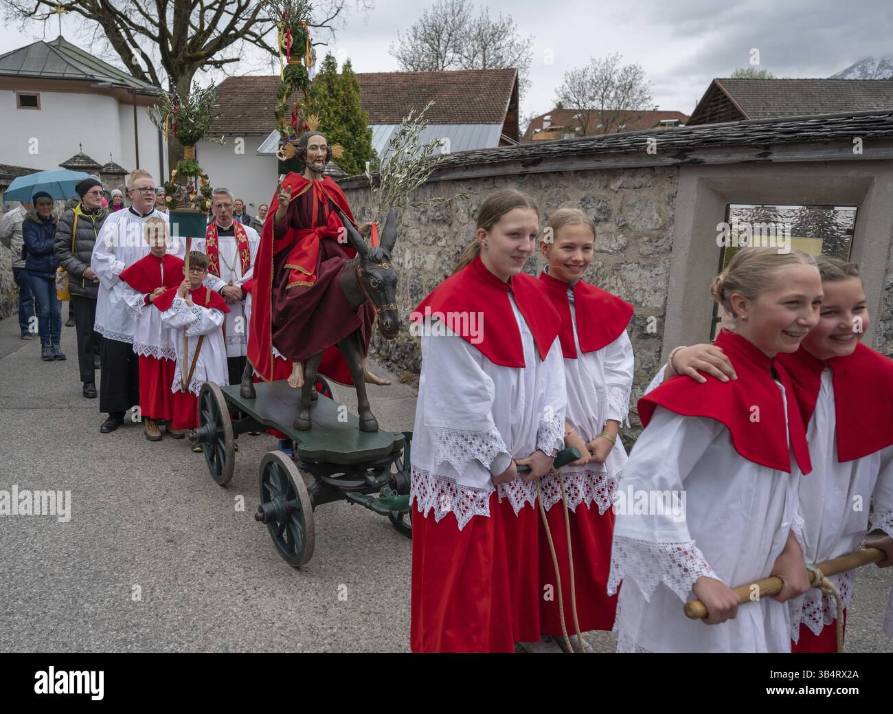 Altar servers pull the palm donkey for the palm procession, tradition ...