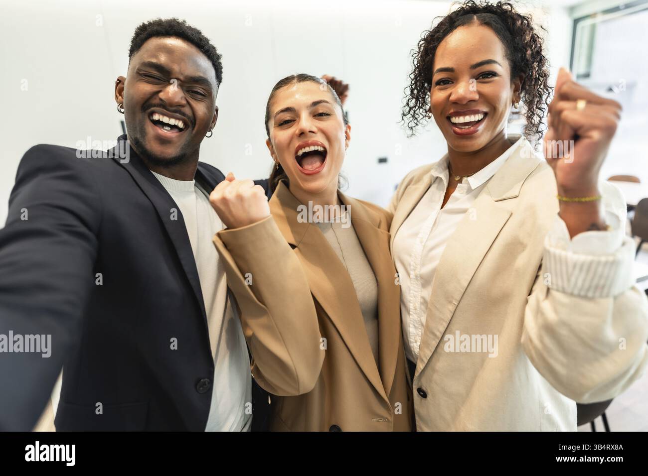 Enthusiastic businesspeople cheering and expressing joy after achieving ...