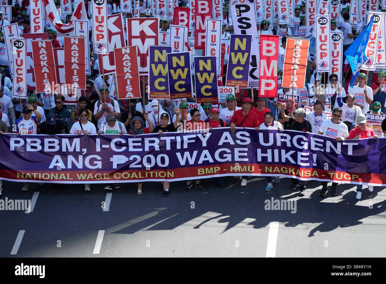 Activist and workers hold slogans during a May Day rally in Manila ...