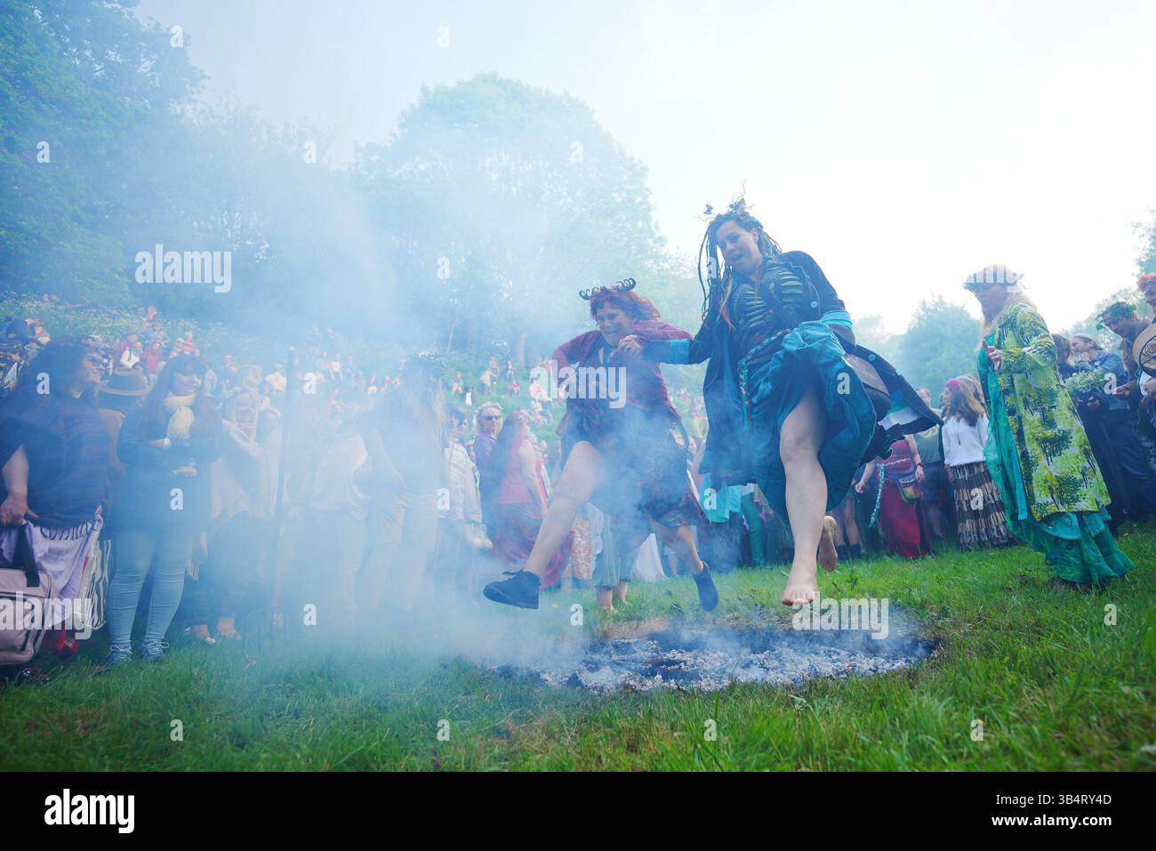 People jump the fire during the Beltane celebrations at Glastonbury ...