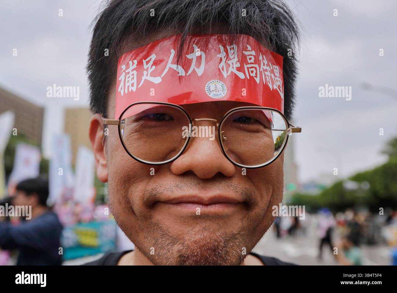 A Taiwanese worker sticks a slogan on the head reading "Supplement ...