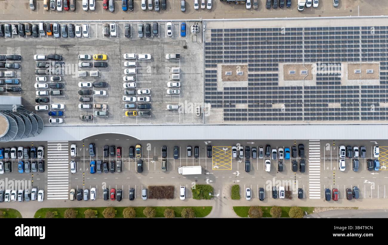 Aerial view of a large parking lot filled with cars, featuring ...