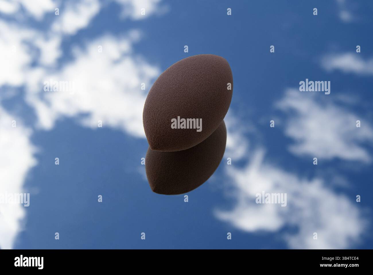 Brown sponge on glass. Blue sky with white clouds. Horizontal photo ...