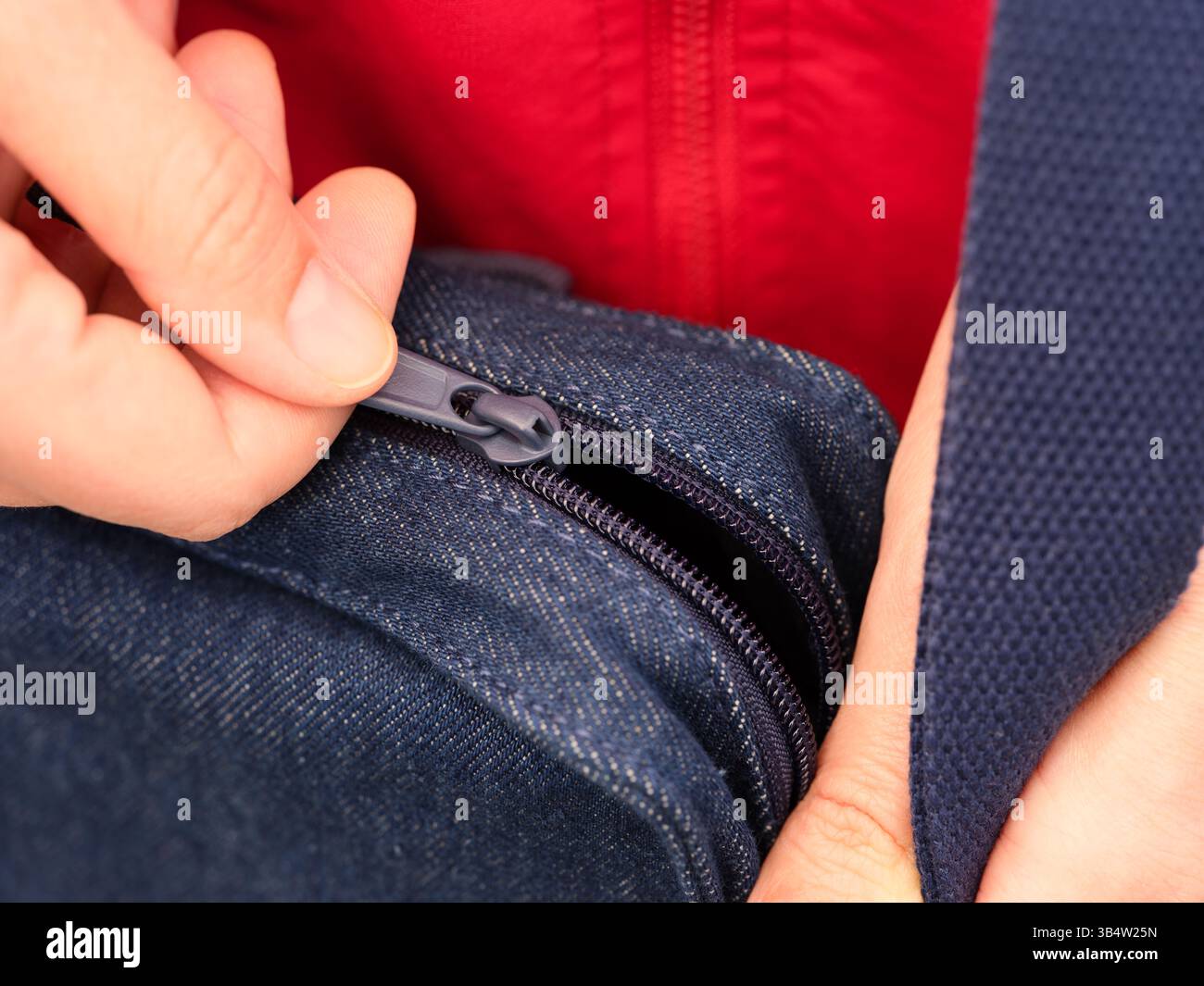 Close-up shot of woman hands pulling up the zip on her denim bag Stock ...