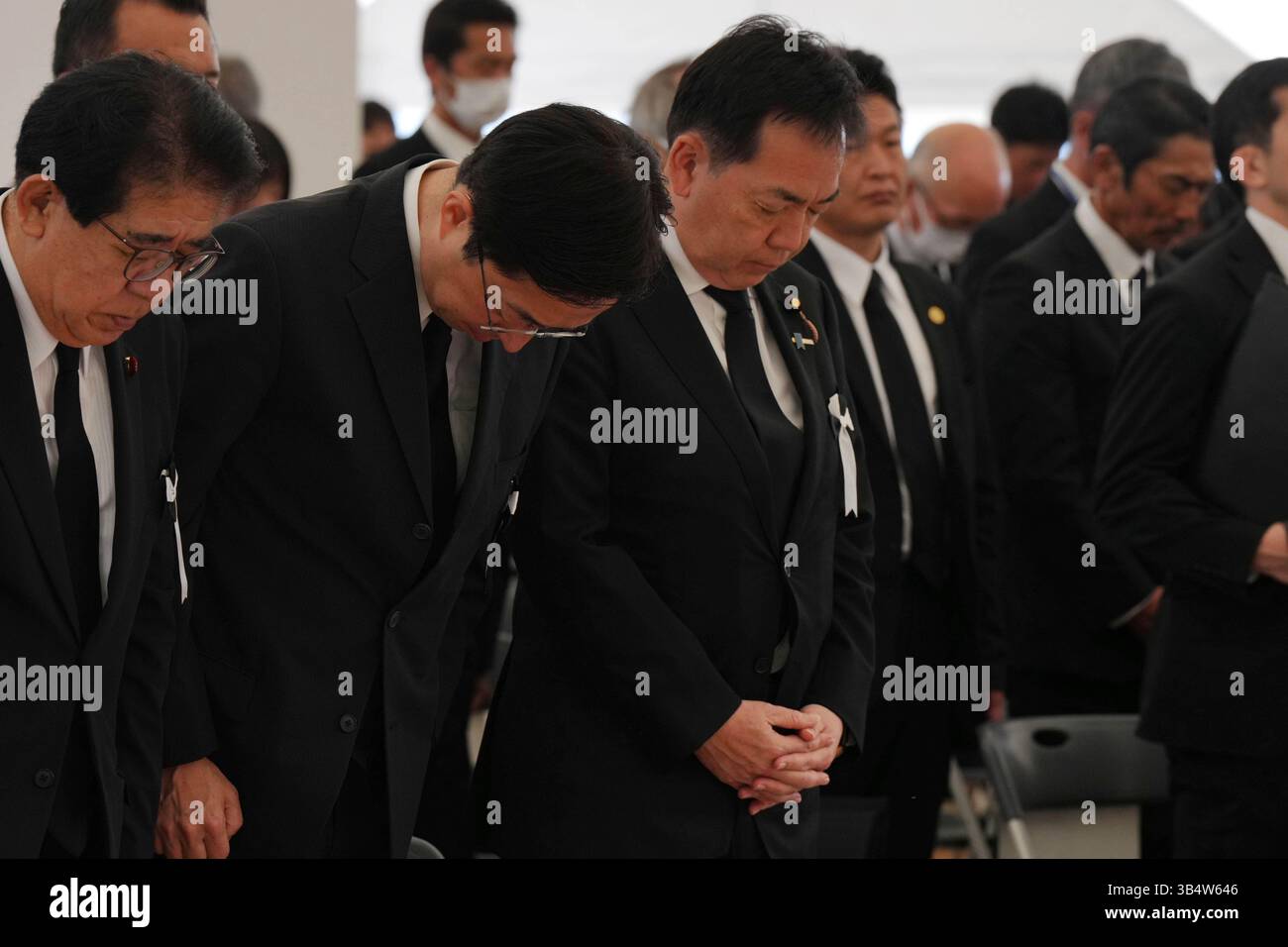 Japanese Environment Minister Keiichiro ASAO (C) pray silently during ...